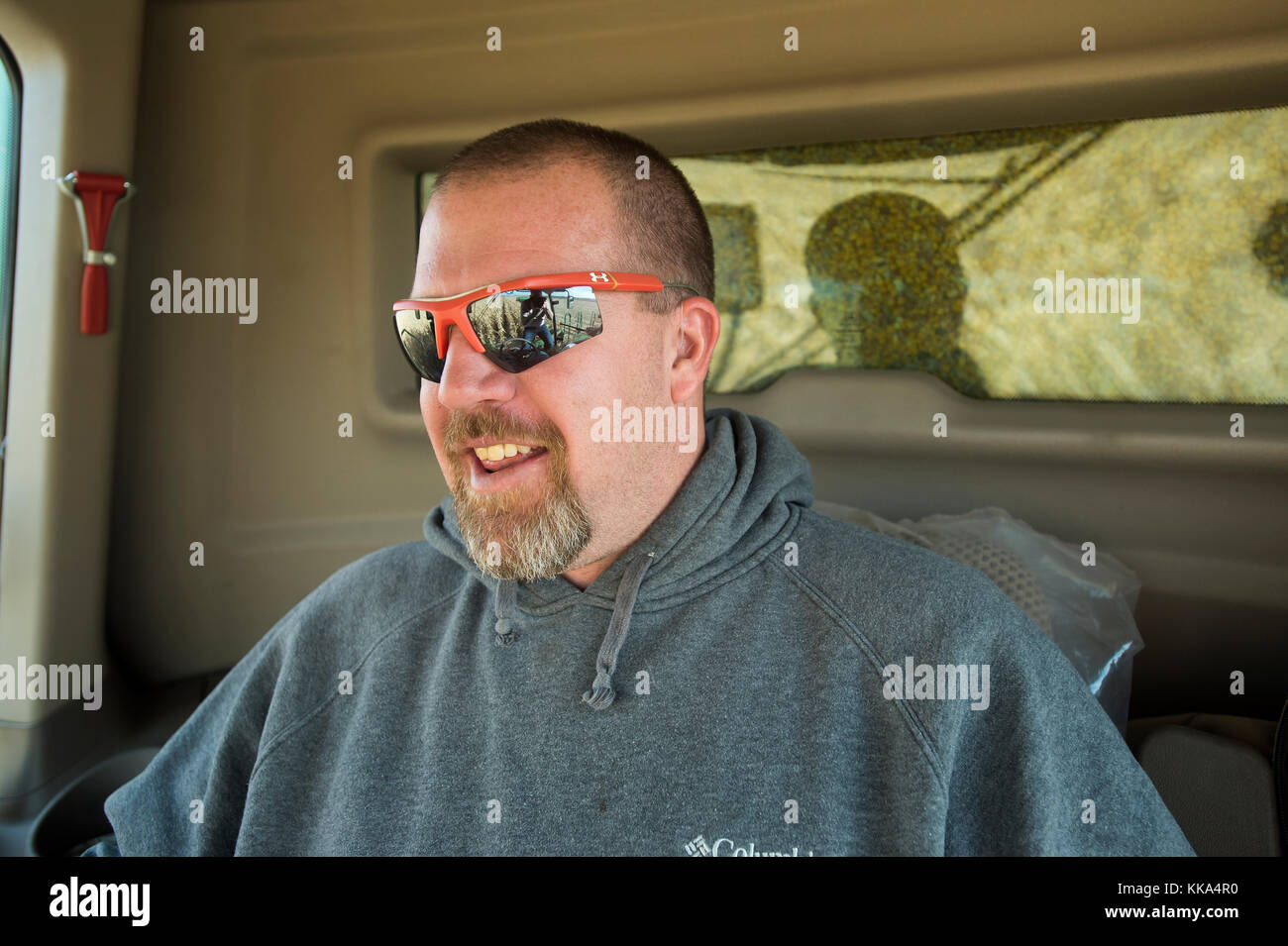 FARMER CLOSE UP PORTRAIT OPERATING COMBINE HARVESTER IN CORN FIELD IN ...