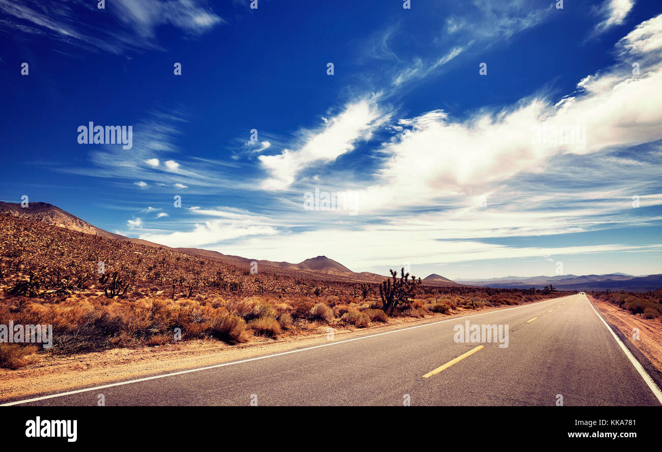 Vintage stylized picture of a Death Valley deserted road, travel ...