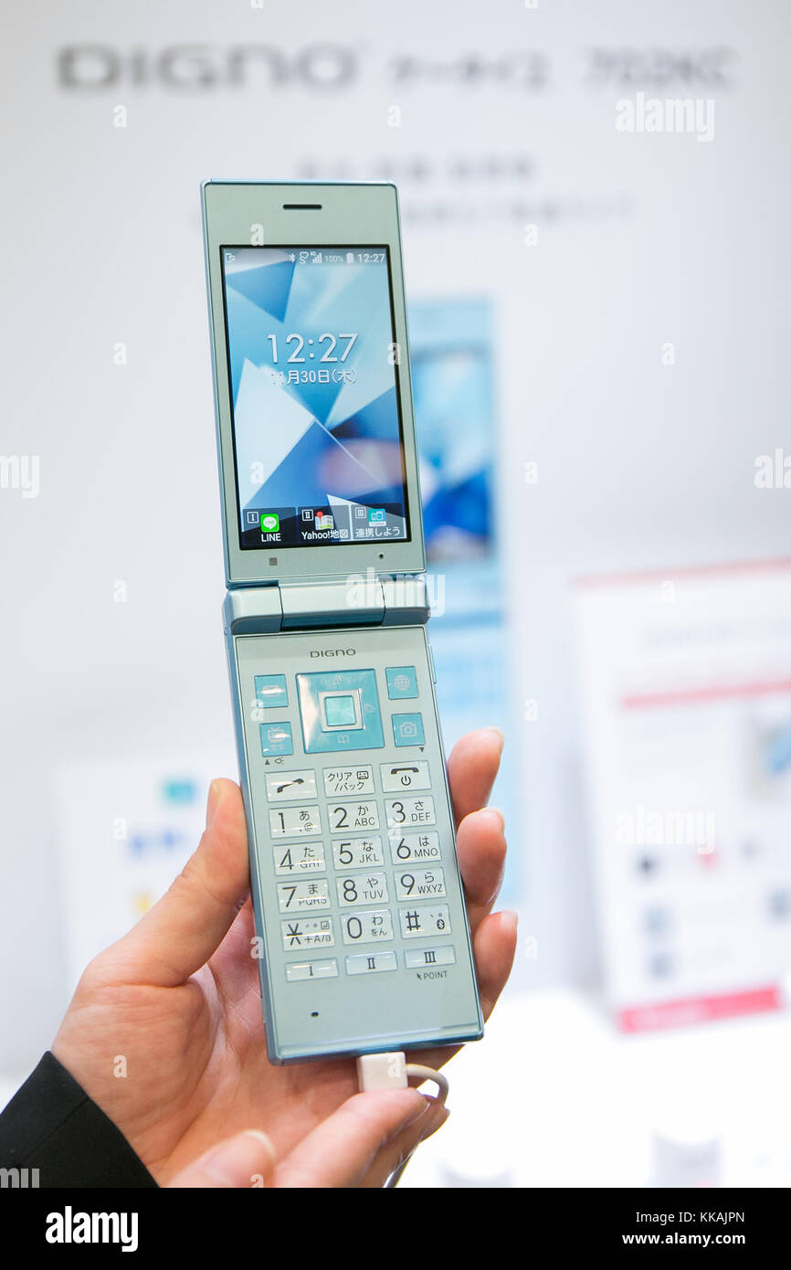 An exhibitor shows a Dingo Keitai 2 during a launch event for Y!mobile ...