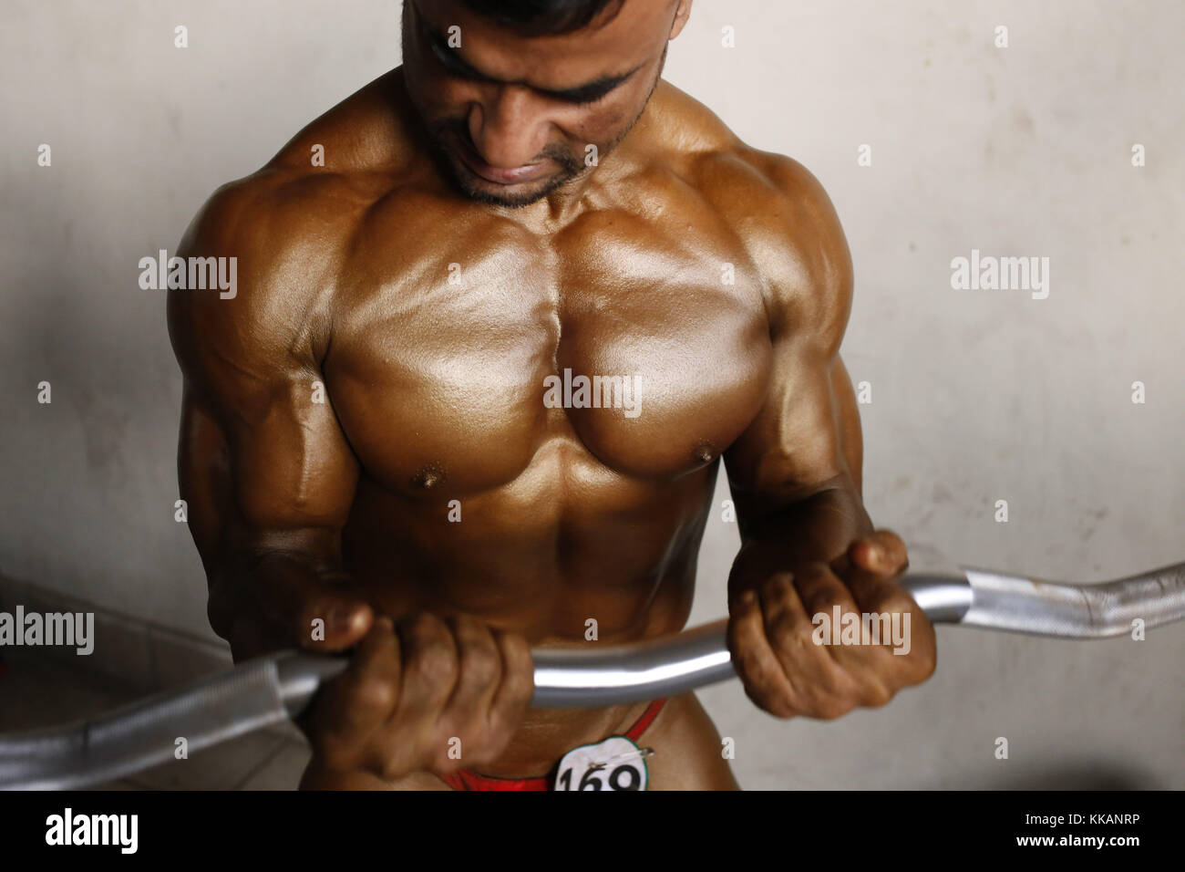 Dhaka, Bangladesh. 30th Nov, 2017. A Bodybuilder warms up backstage ...