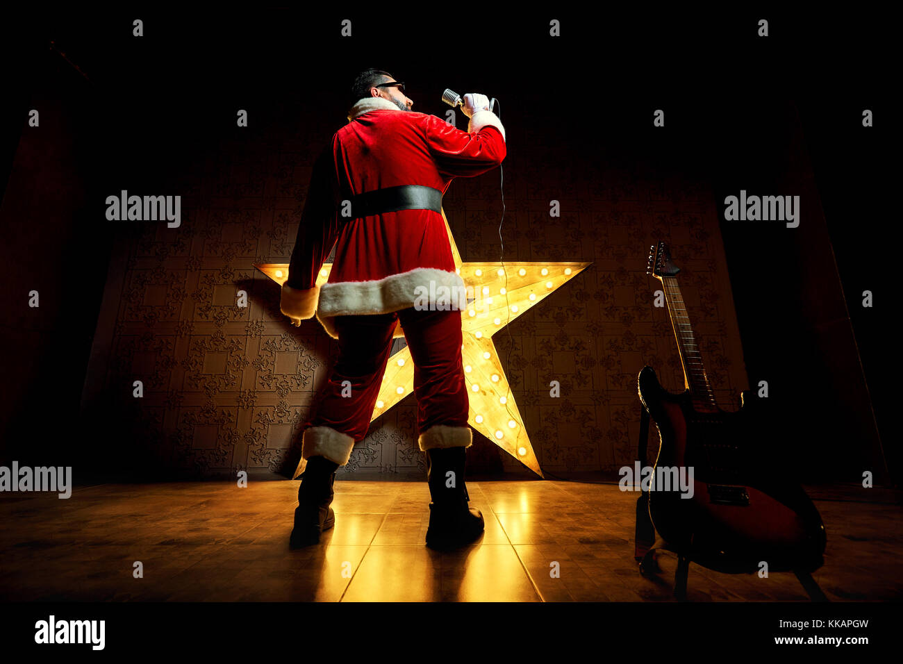Happy Santa sings into the microphone against the backdrop of a Stock ...