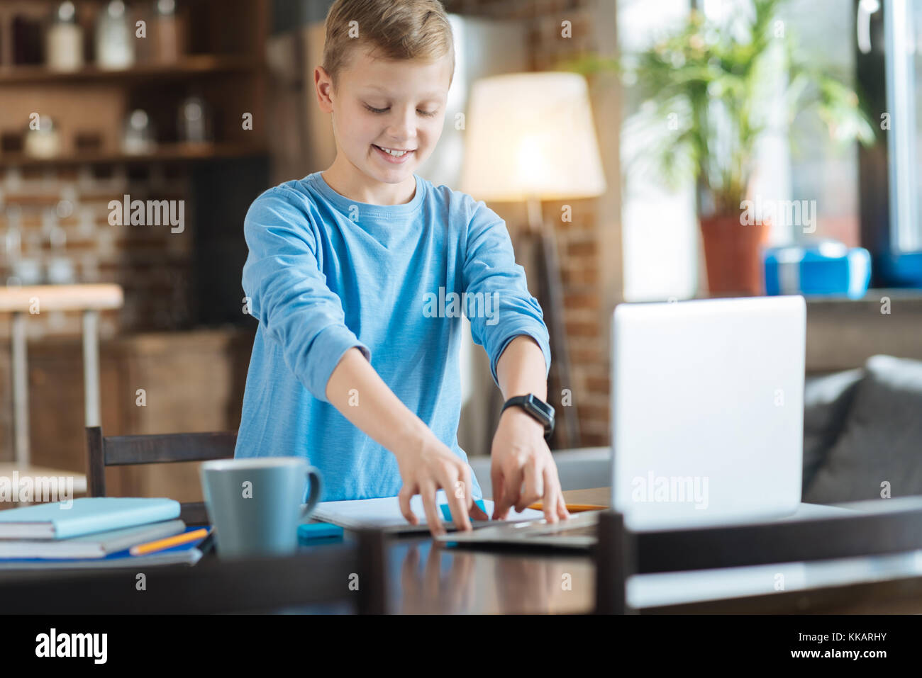 Positive nice boy looking at his copy book Stock Photo - Alamy