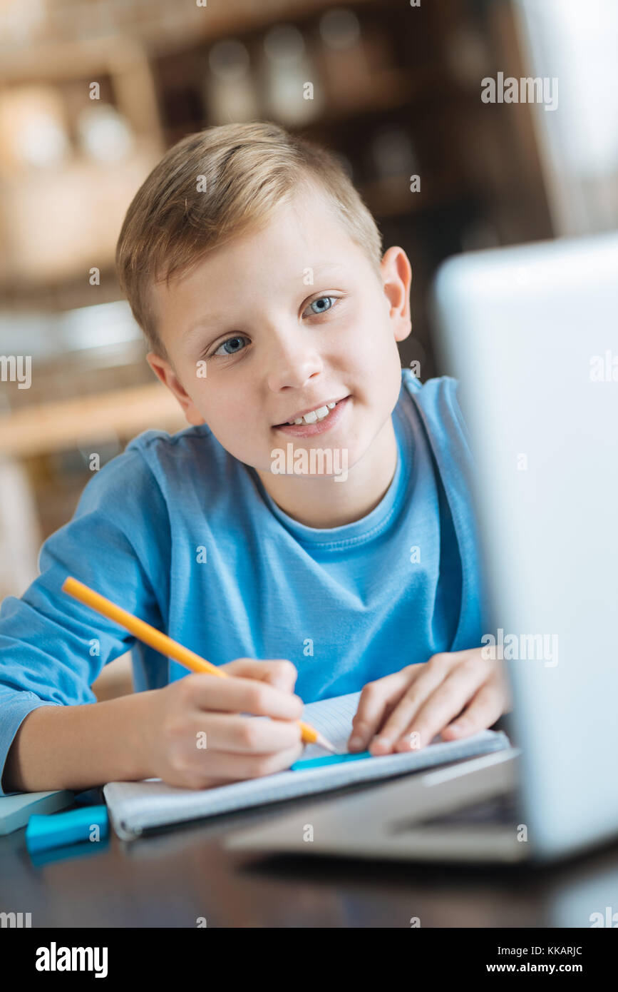 Delighted nice boy looking at the laptop screen Stock Photo - Alamy