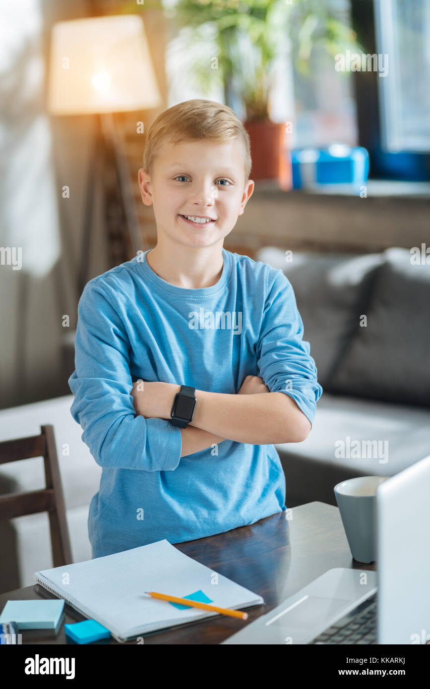 Delighted nice boy standing cross handed Stock Photo - Alamy