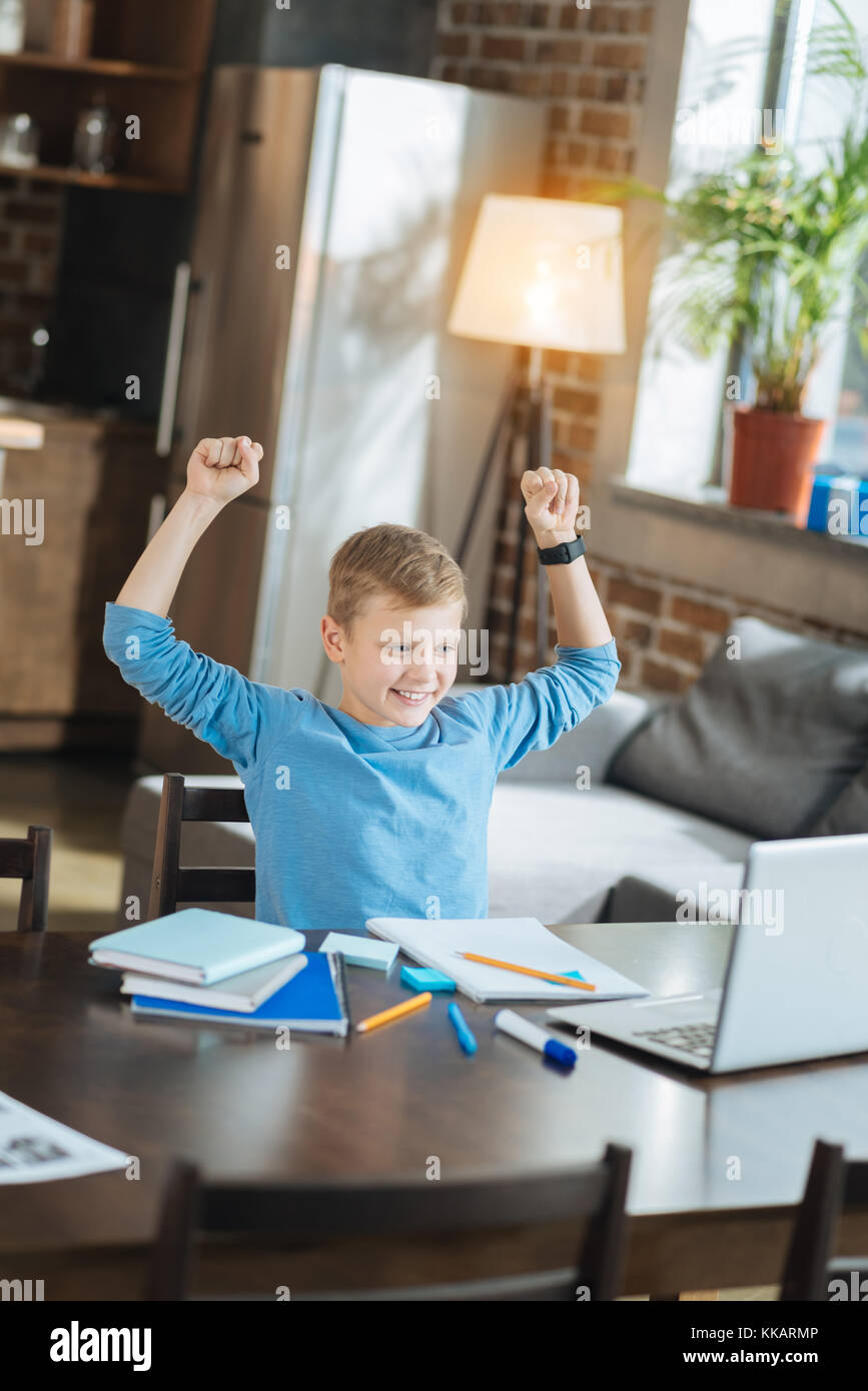 Delighted emotional boy holding his hands up Stock Photo - Alamy