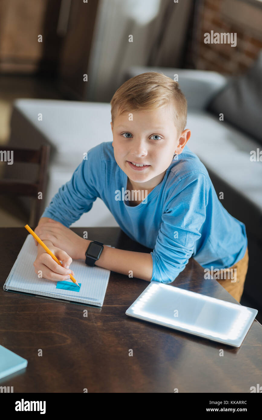 Nice pleasant boy standing near the table Stock Photo - Alamy