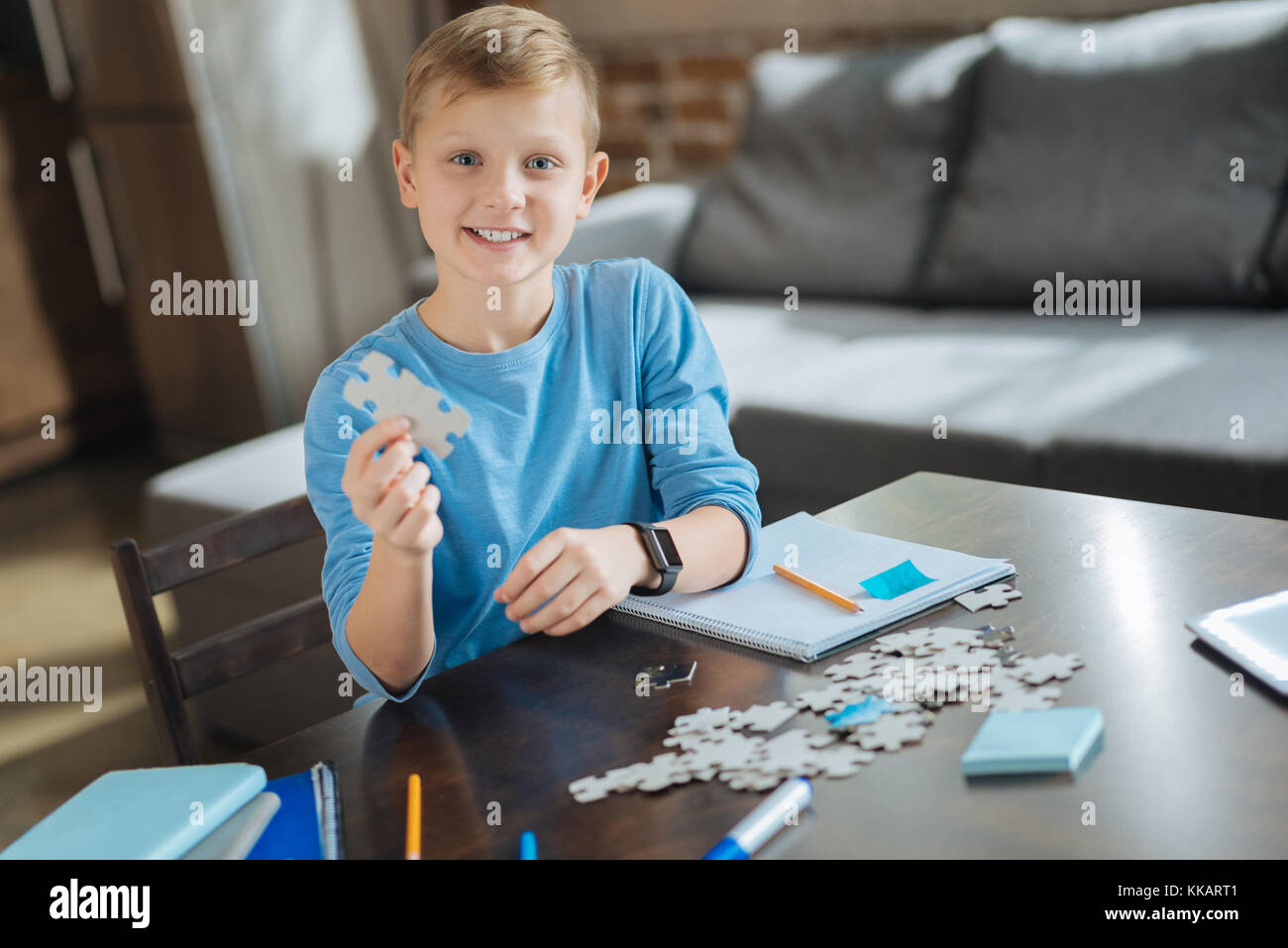 Joyful nice boy collecting puzzles Stock Photo - Alamy