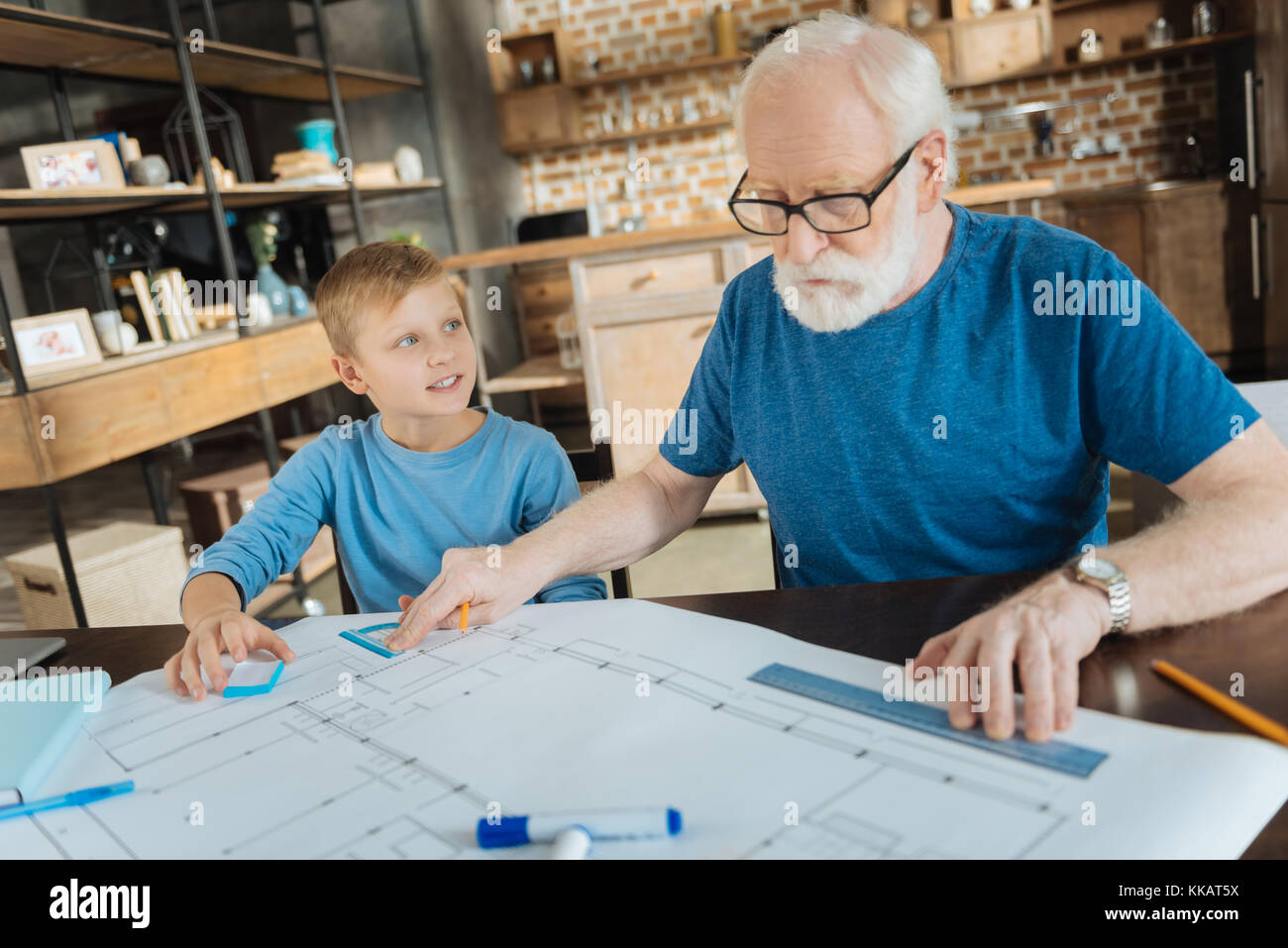 Professional aged engineer working with his grandson Stock Photo - Alamy