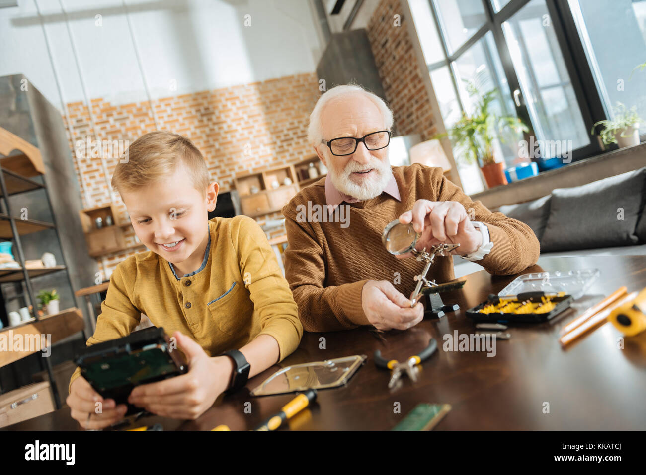 Positive cheerful grandfather and grandson enjoying their time Stock ...