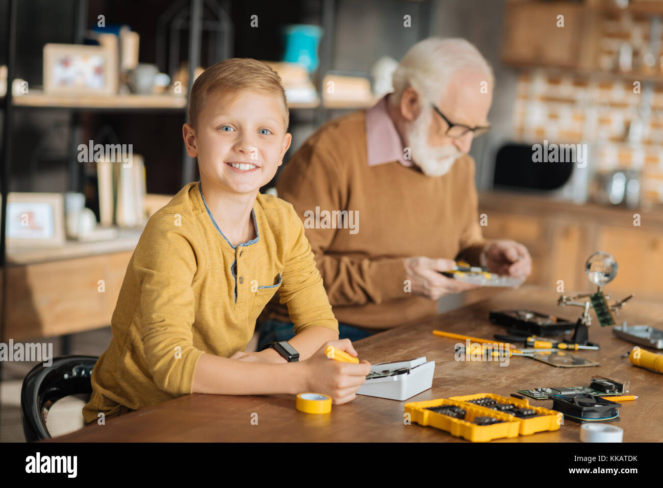 Joyful positive boy sitting at the table Stock Photo - Alamy