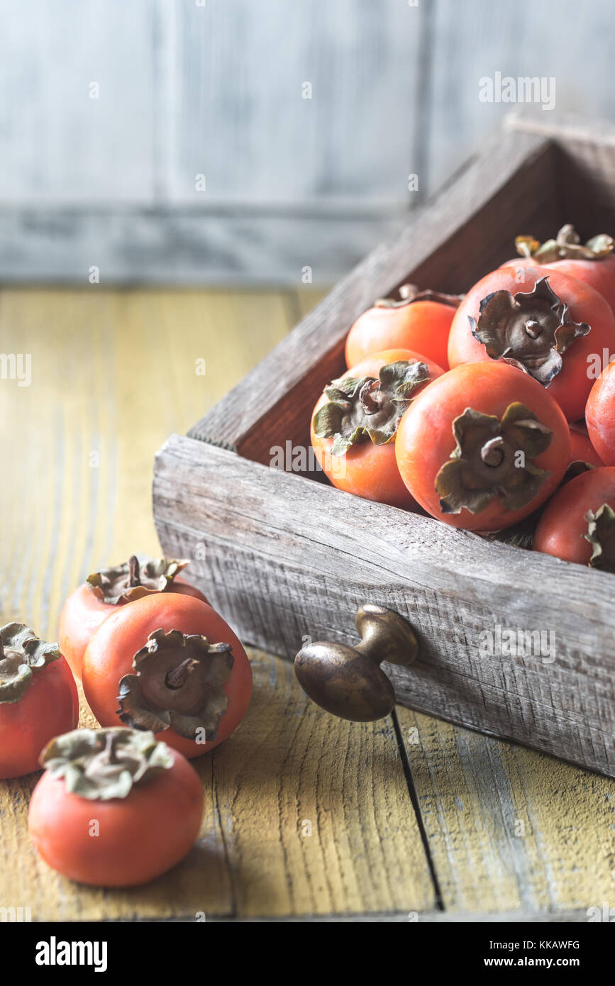 Wooden box of fresh persimmons Stock Photo - Alamy