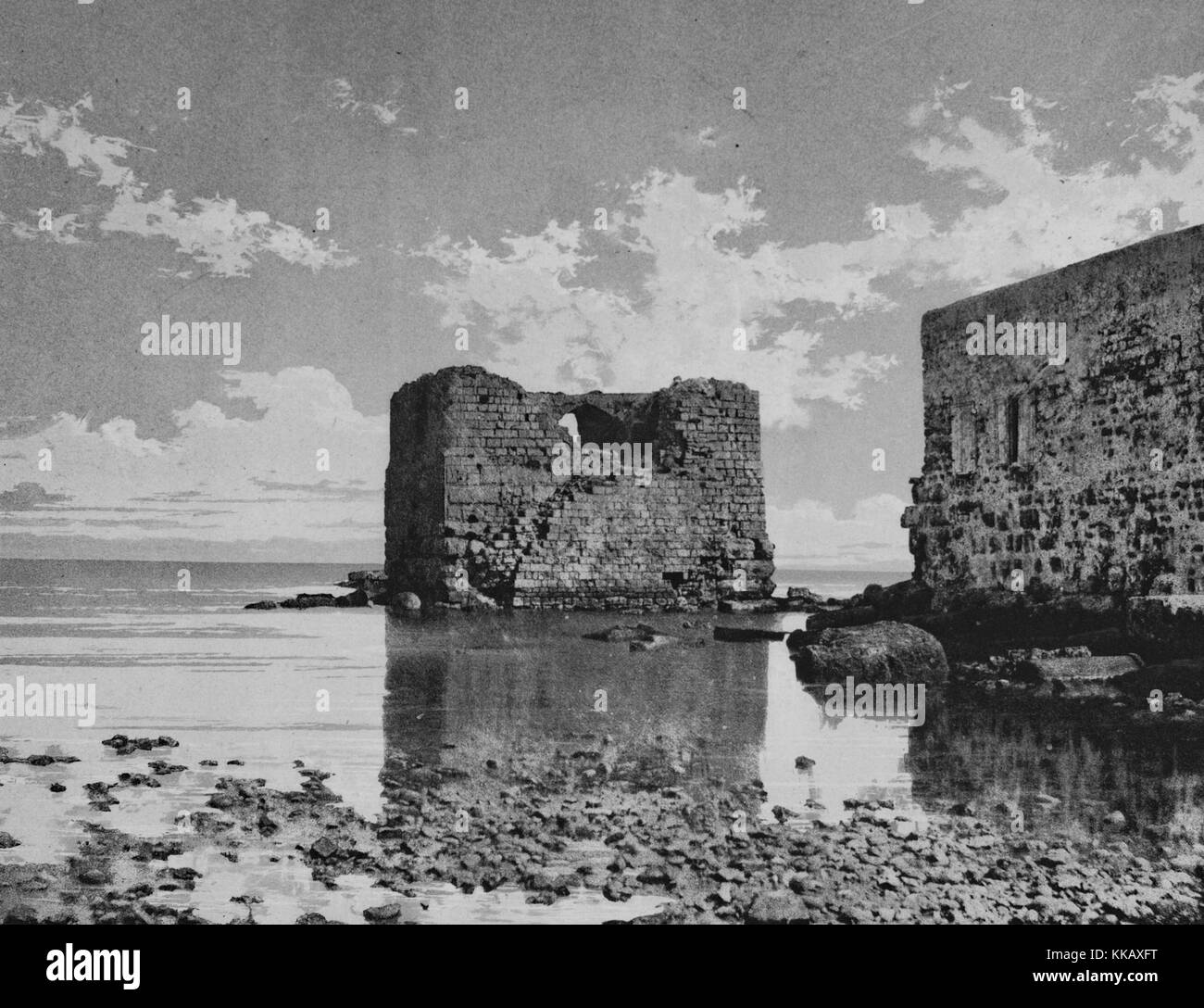 Black and white photograph of a shore, stone ruins in the shallow ...