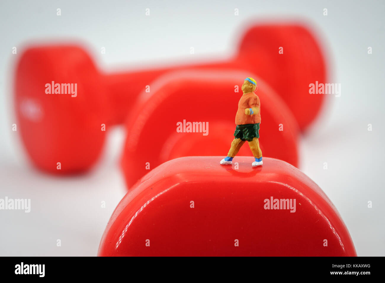 Sport and fitness concept. Man runner miniature figure running on red ...