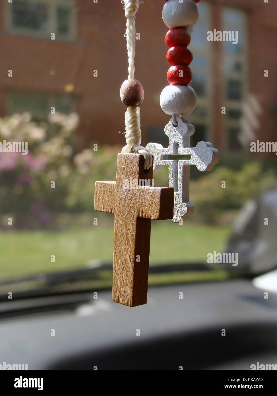 Two crucifixes hanging in car front window close up Stock Photo - Alamy