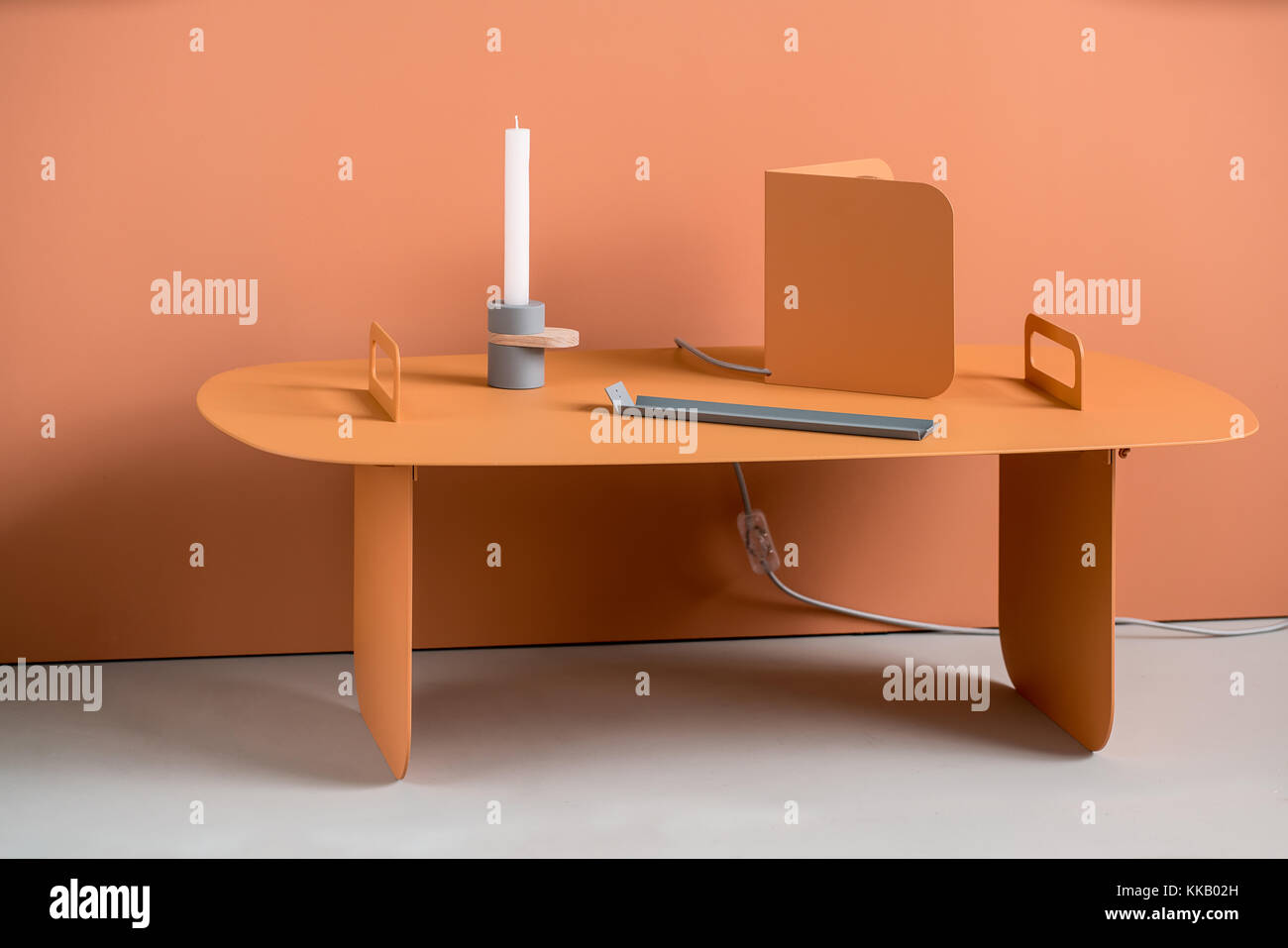 Metal orange table with lamp and accessories Stock Photo - Alamy