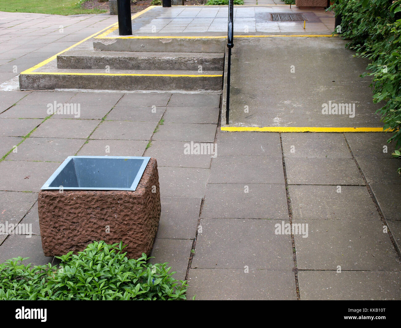 Building entrance with concrete steps and ramp for disabled person ...