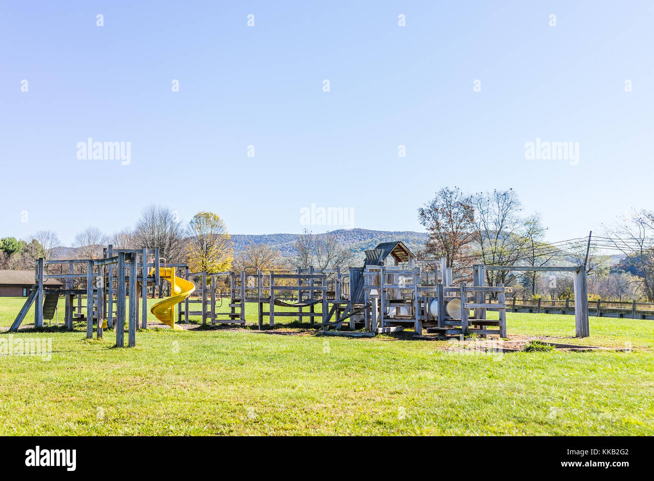 Wooden children's playground empty in countryside by school with slide ...