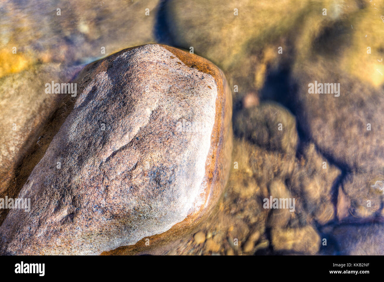 Closeup of shallow rock stream with running water in autumn with one ...