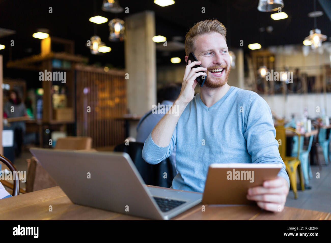 Young happy man having phone call in cafe Stock Photo - Alamy