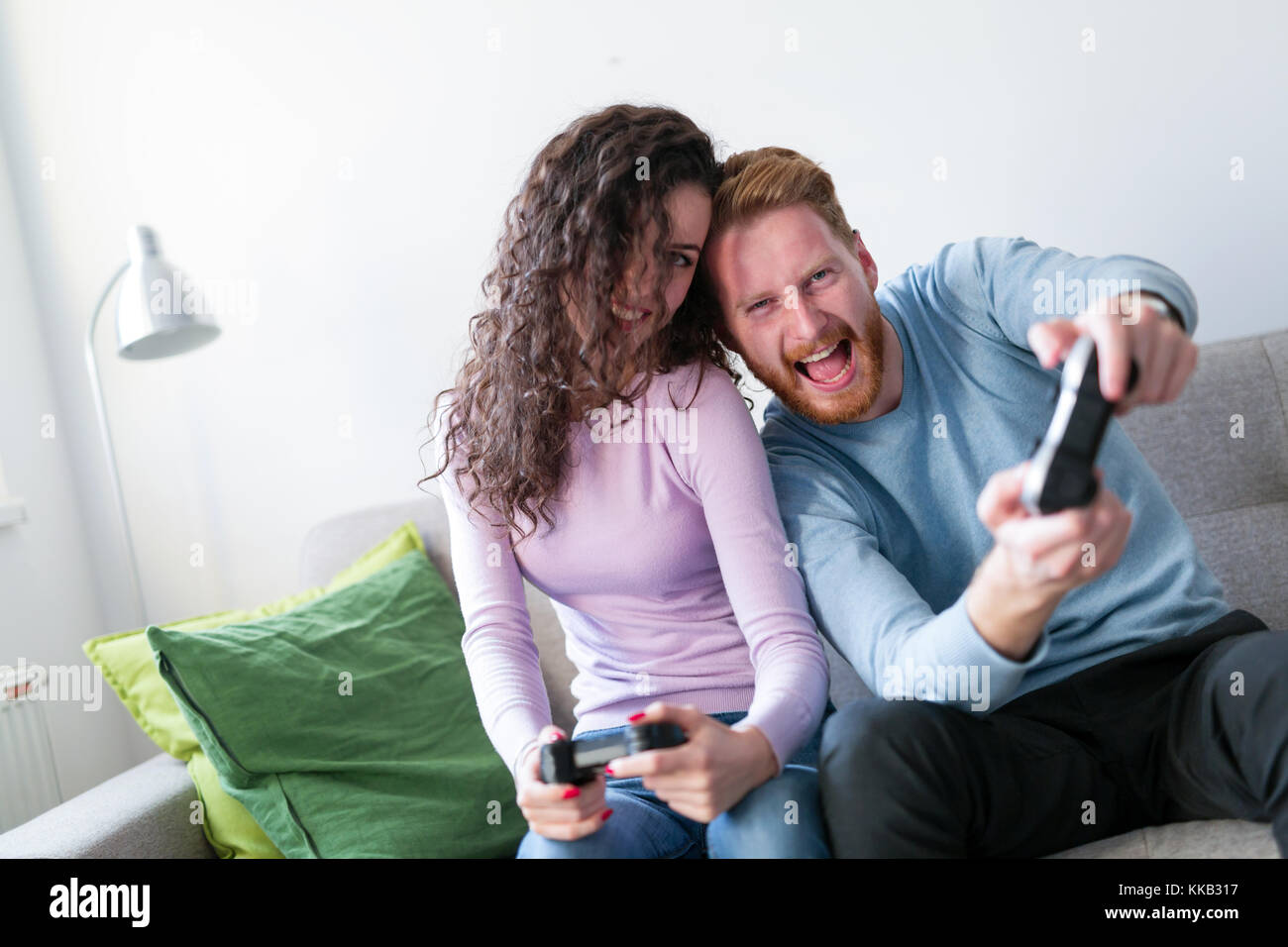 Young couple having fun playing video games Stock Photo - Alamy