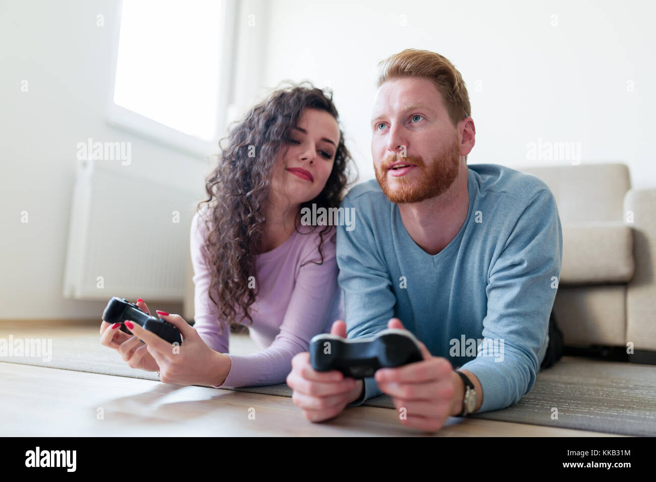 Young couple having fun playing video games Stock Photo - Alamy
