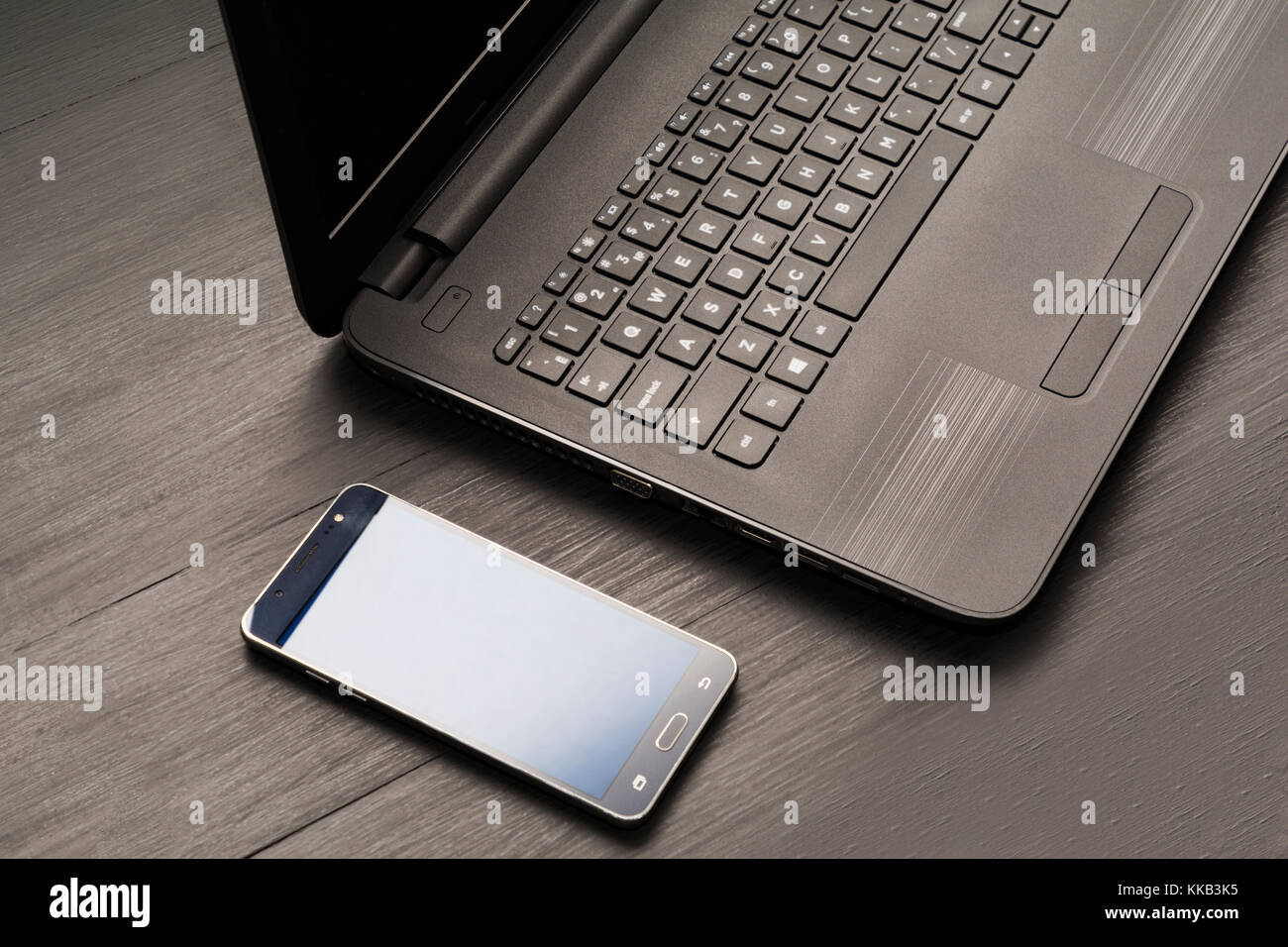 Computer Laptop and mobile phone on dark wooden table background, copy ...