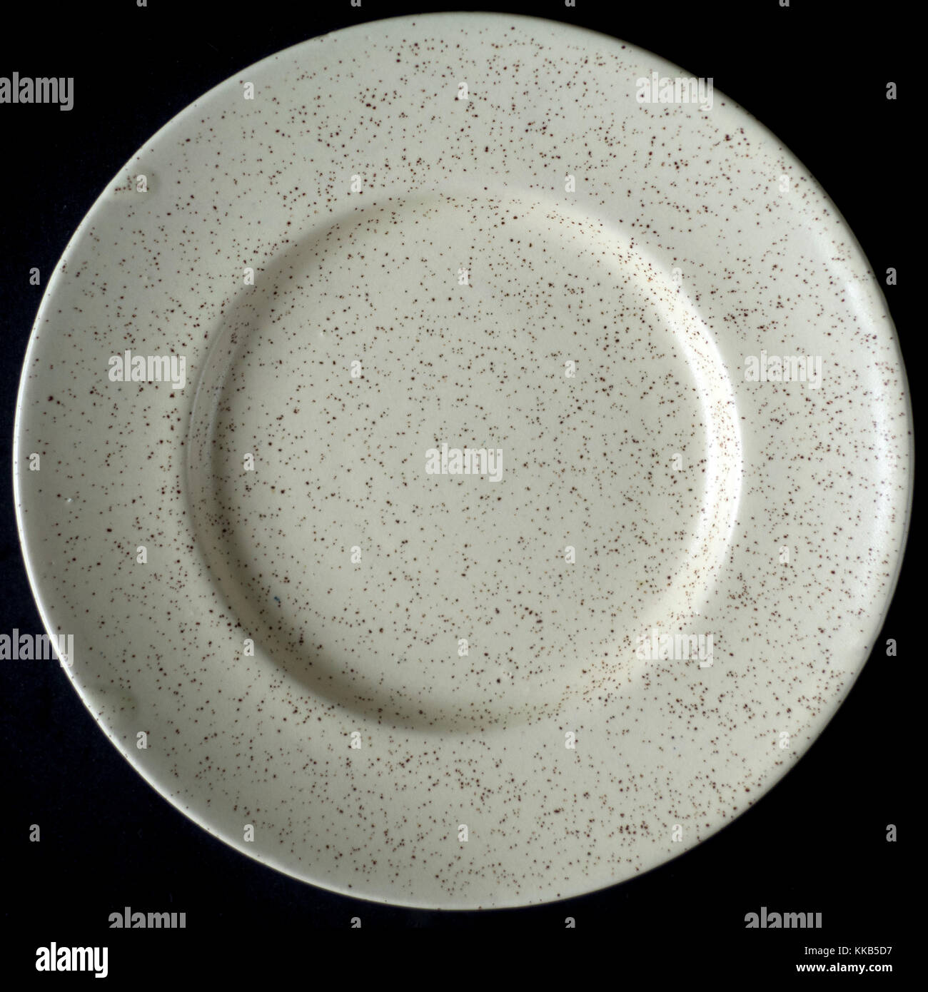 high above view of cream-colored plate isolated on black background ...
