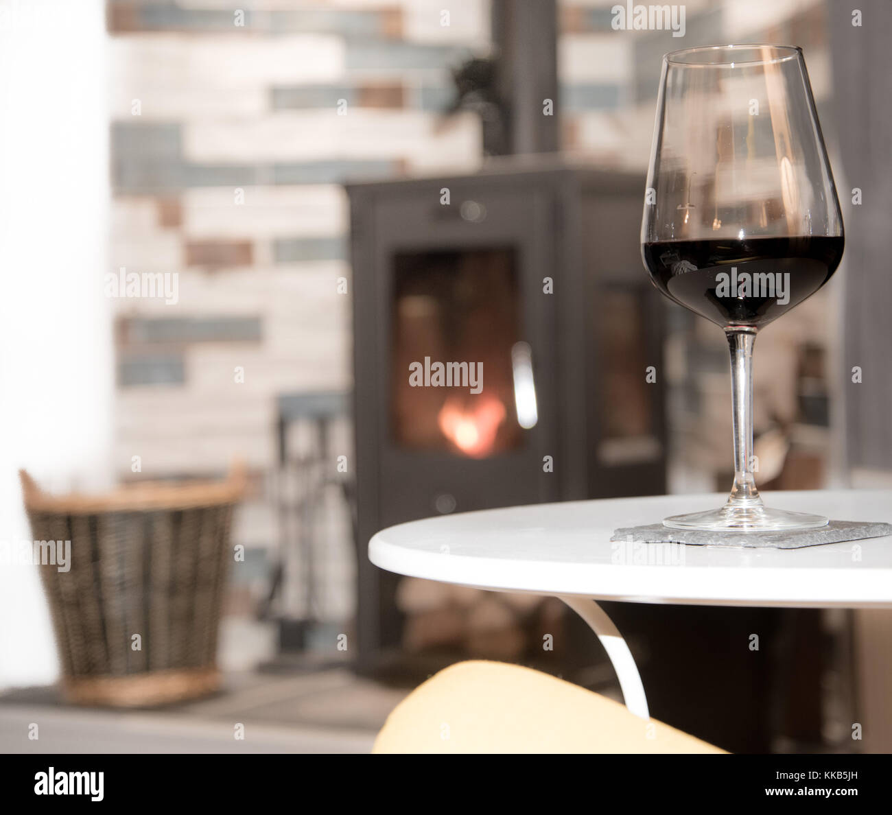 Glass of red wine and fire in stove - romantic living room scenery ...