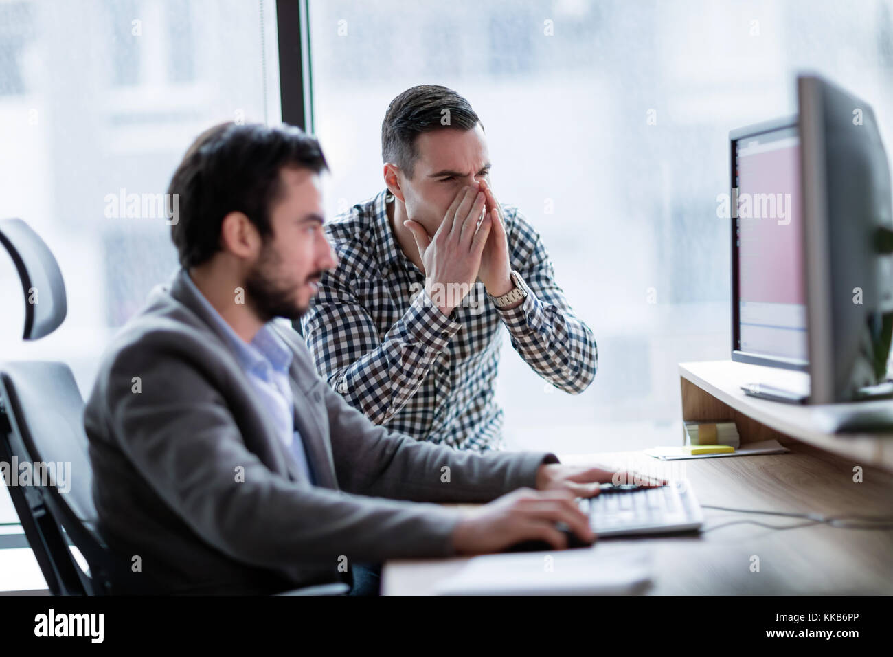 Coworkers having problem with computer in office Stock Photo - Alamy