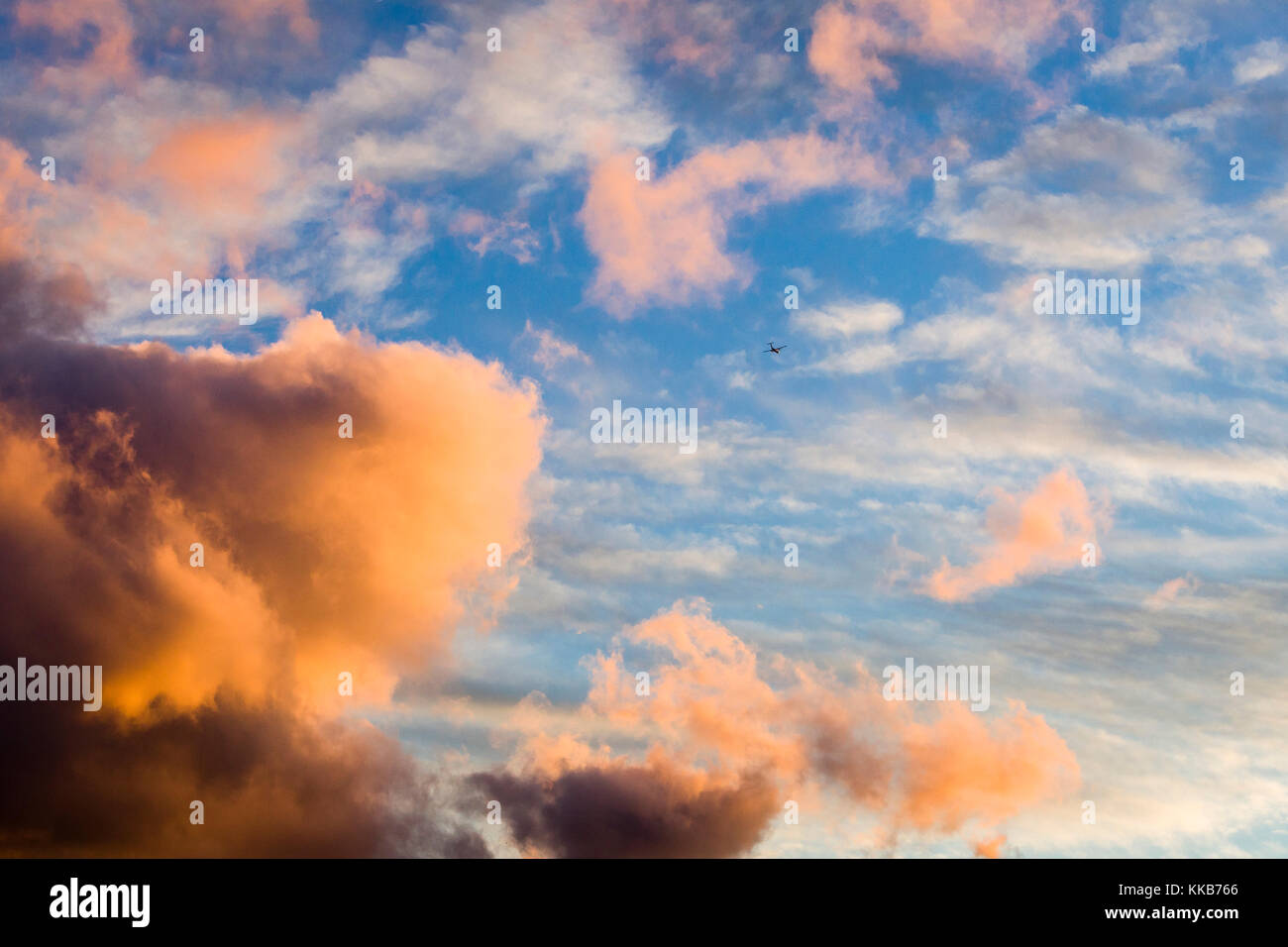 Dramatic Orange clouds against a blue sky with passenger jet Stock ...