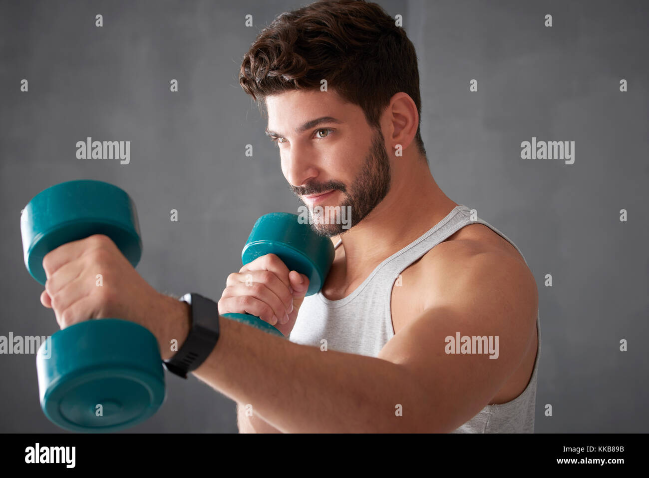 Shot of a young sporty man working out with weights in the gym Stock ...