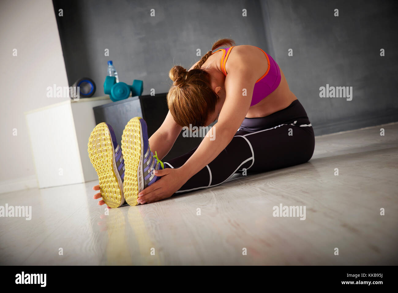 Full length shot of a young woman stretching after workout at the gym ...
