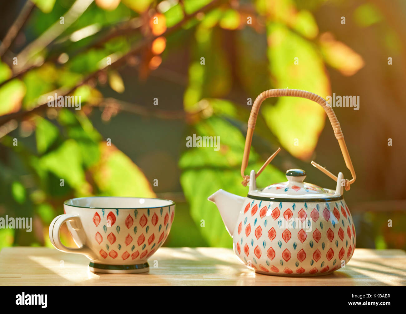 Tea set on sunny light with blurred natural background Stock Photo - Alamy