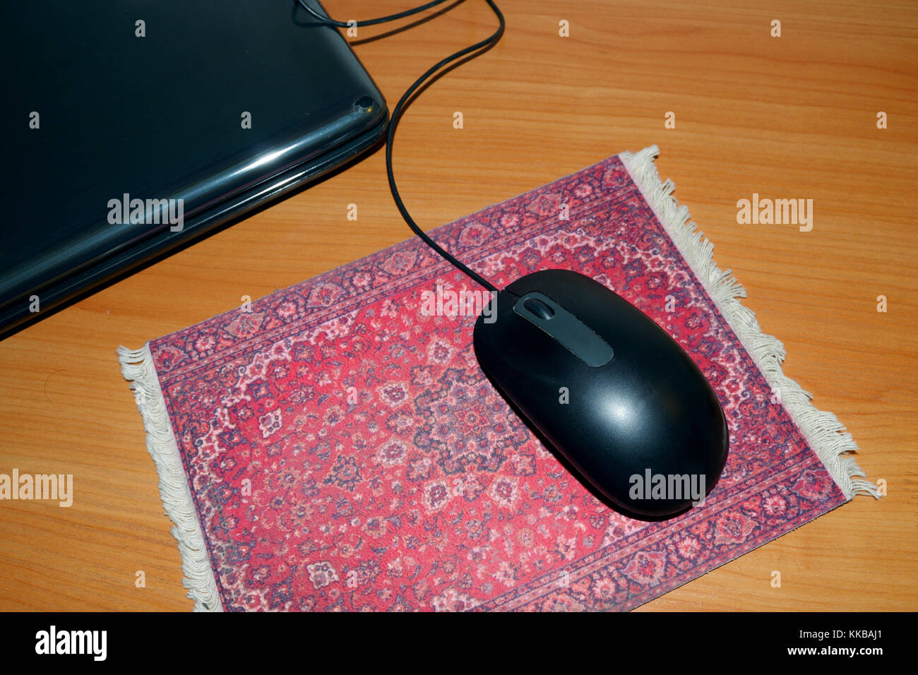 Computer mouse black lies on the Mat on the table Stock Photo - Alamy