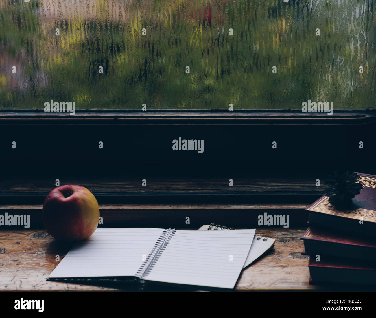 Rainy day by the window with books, notepad and apple Stock Photo - Alamy