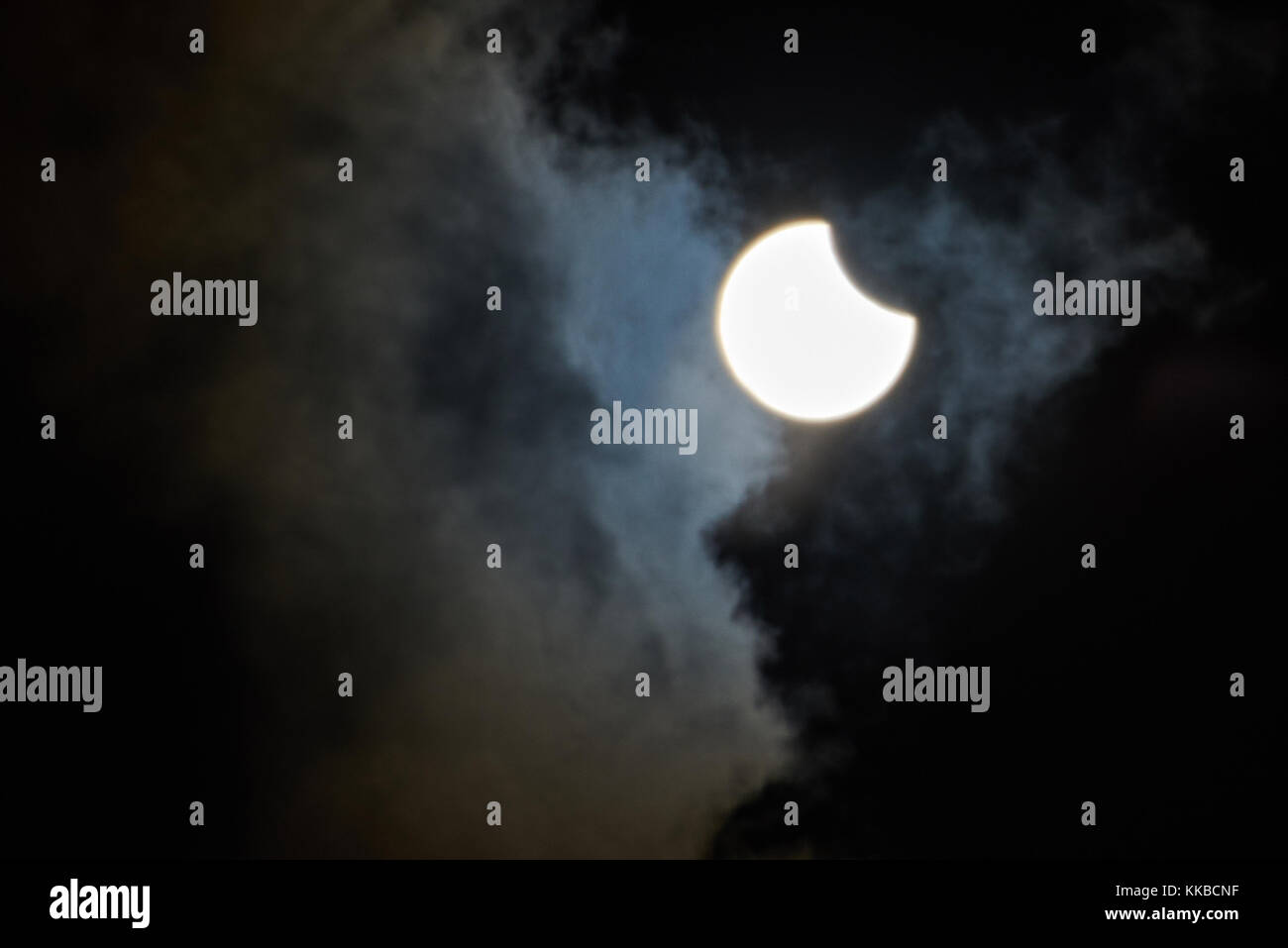 Bright solar eclipse on cloudy sky background Stock Photo - Alamy