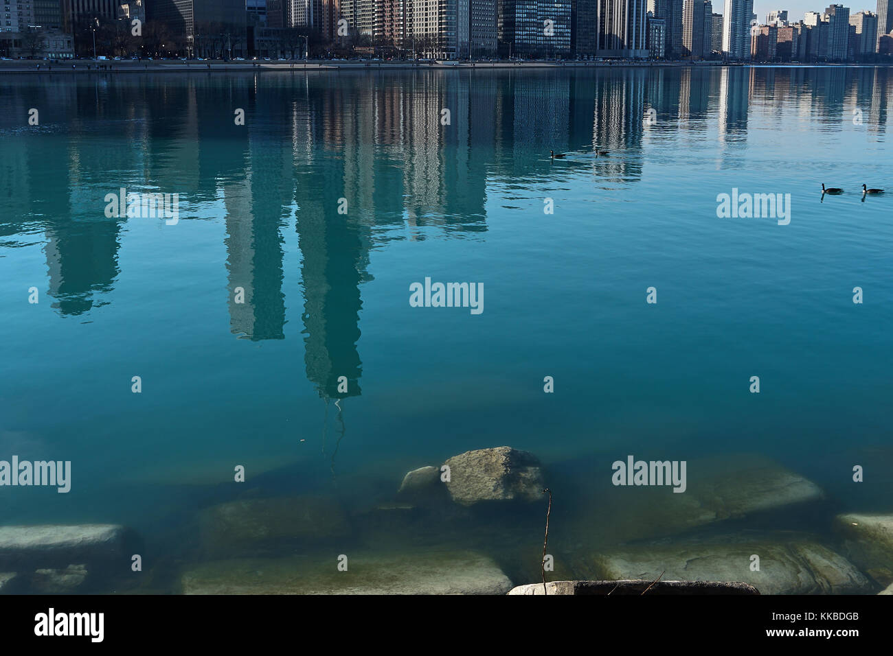 Chicago skyline reflections over calm blue water in Lake Michigan Stock ...