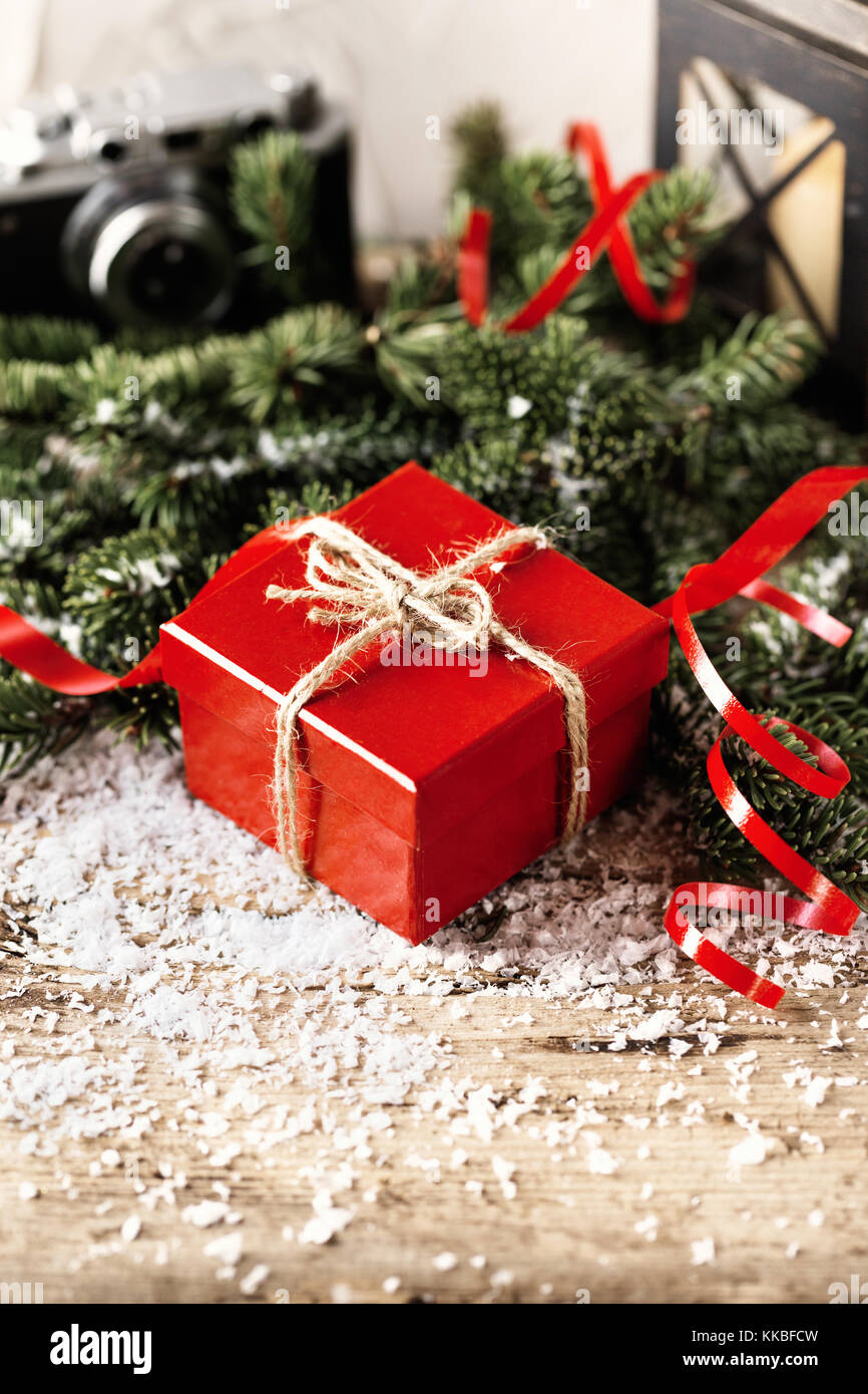 Red present gift box with camera and candle holder on wooden background ...