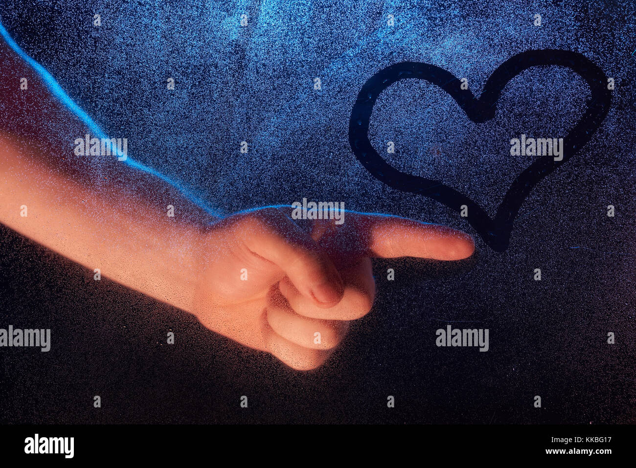 Closeup of man hand draw heart on frozen window abstract background ...
