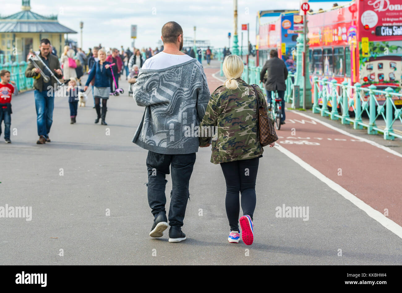 Young couple holding hands walking along a seafront promenade Stock ...