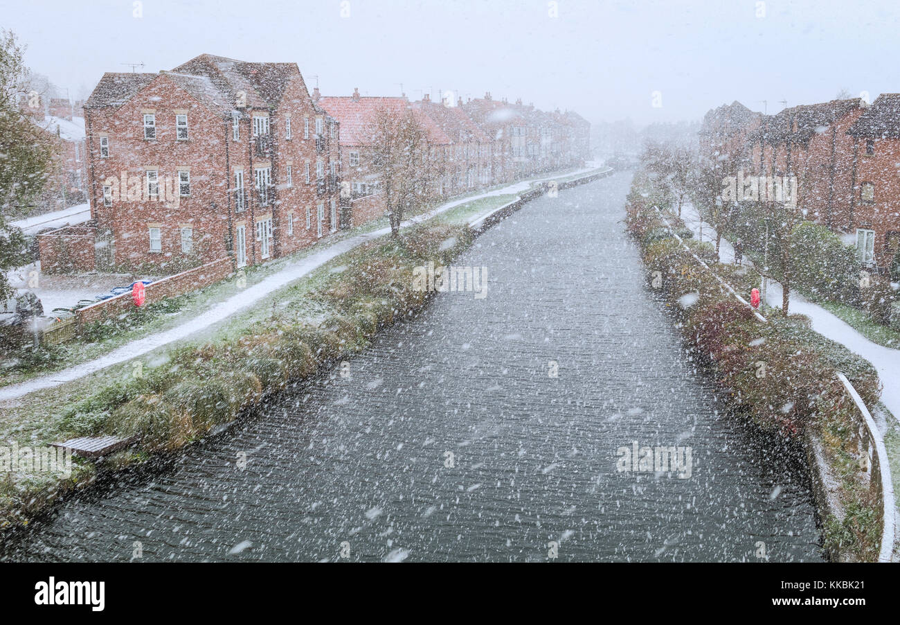 Snow falls over the beck/canal with a light scattering of snow over ...