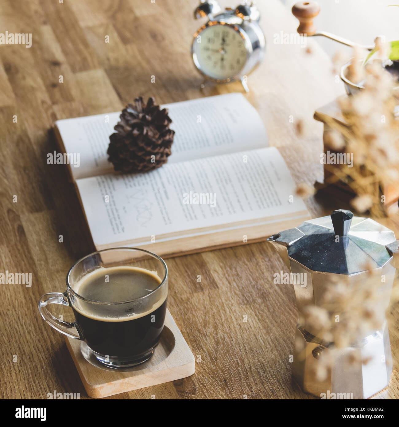 Coffee cup and coffee pot on table with book Stock Photo - Alamy