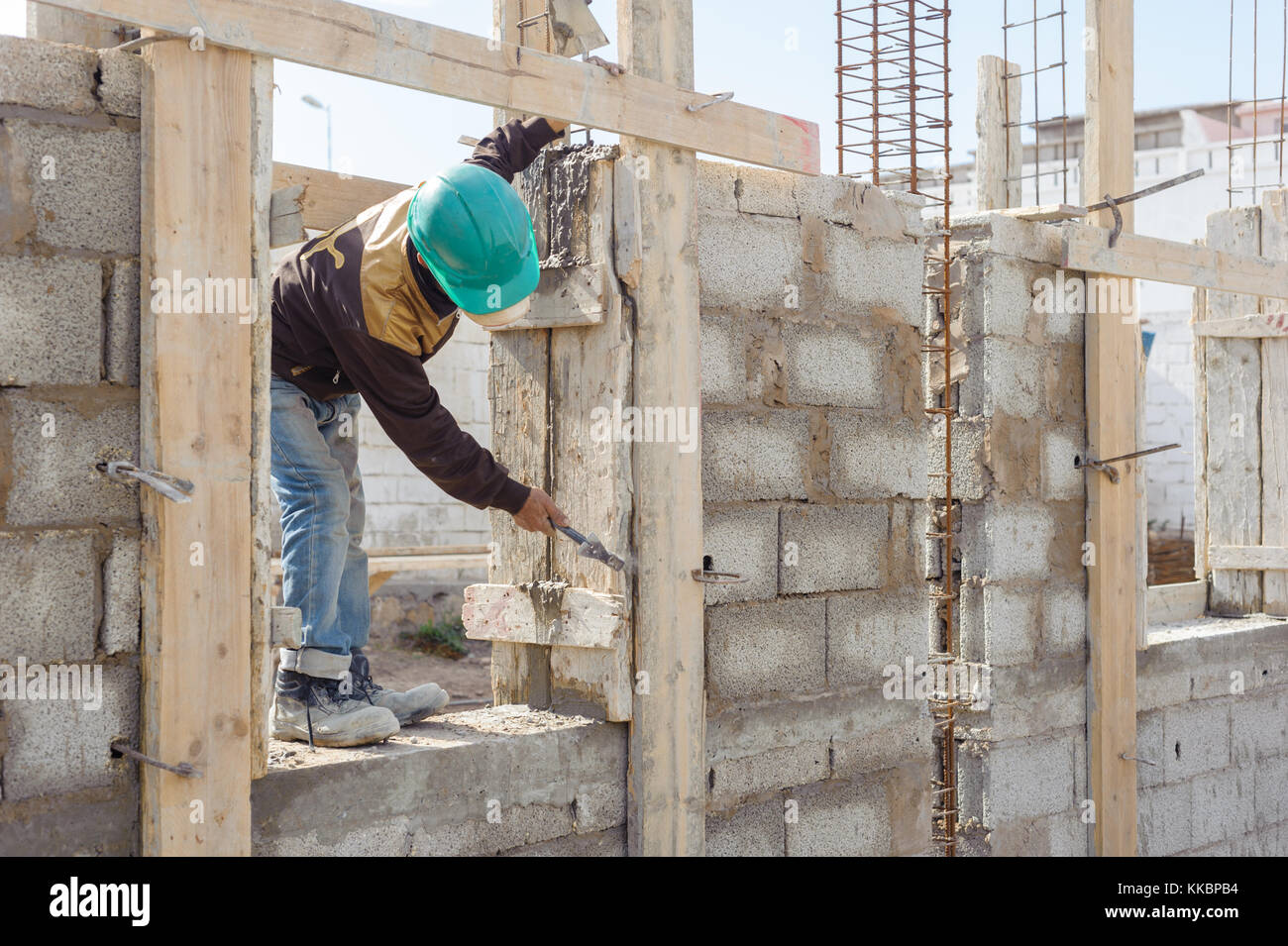 Mason at work using metal nails to fix a wooden structure Stock Photo ...