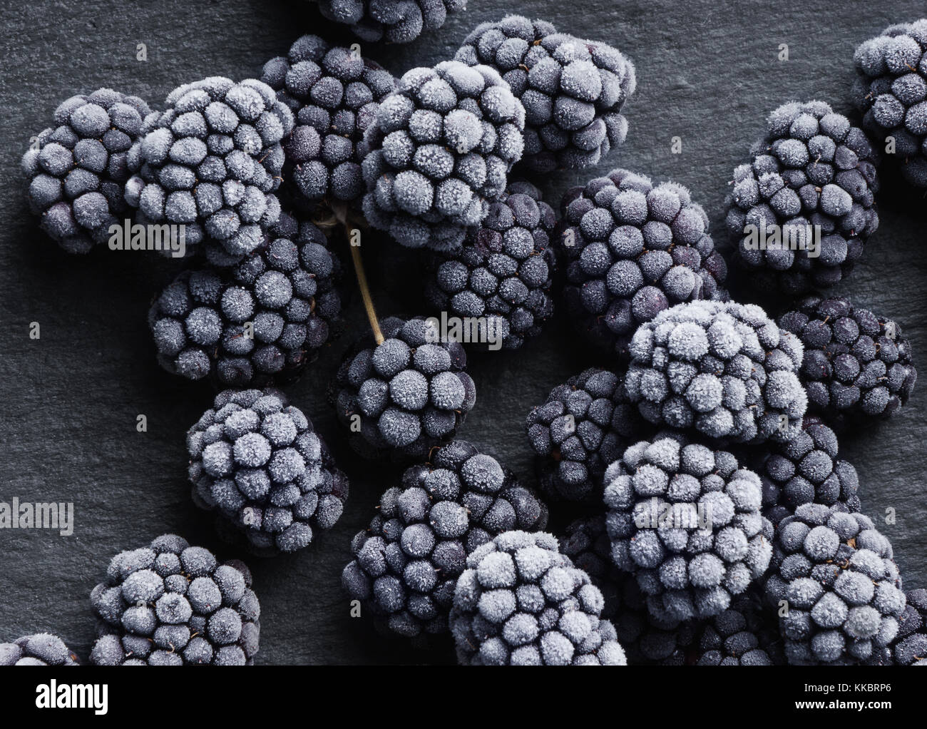 Frozen blackberry on black slate. Top view. High resolution product ...