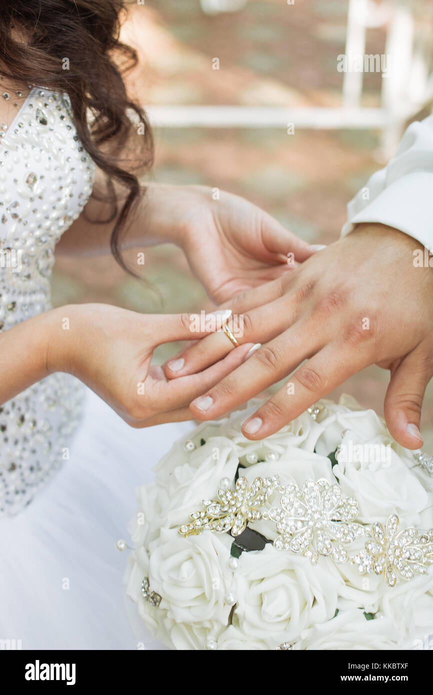 The groom places the ring on the bride's hand. Photo closeup Stock ...