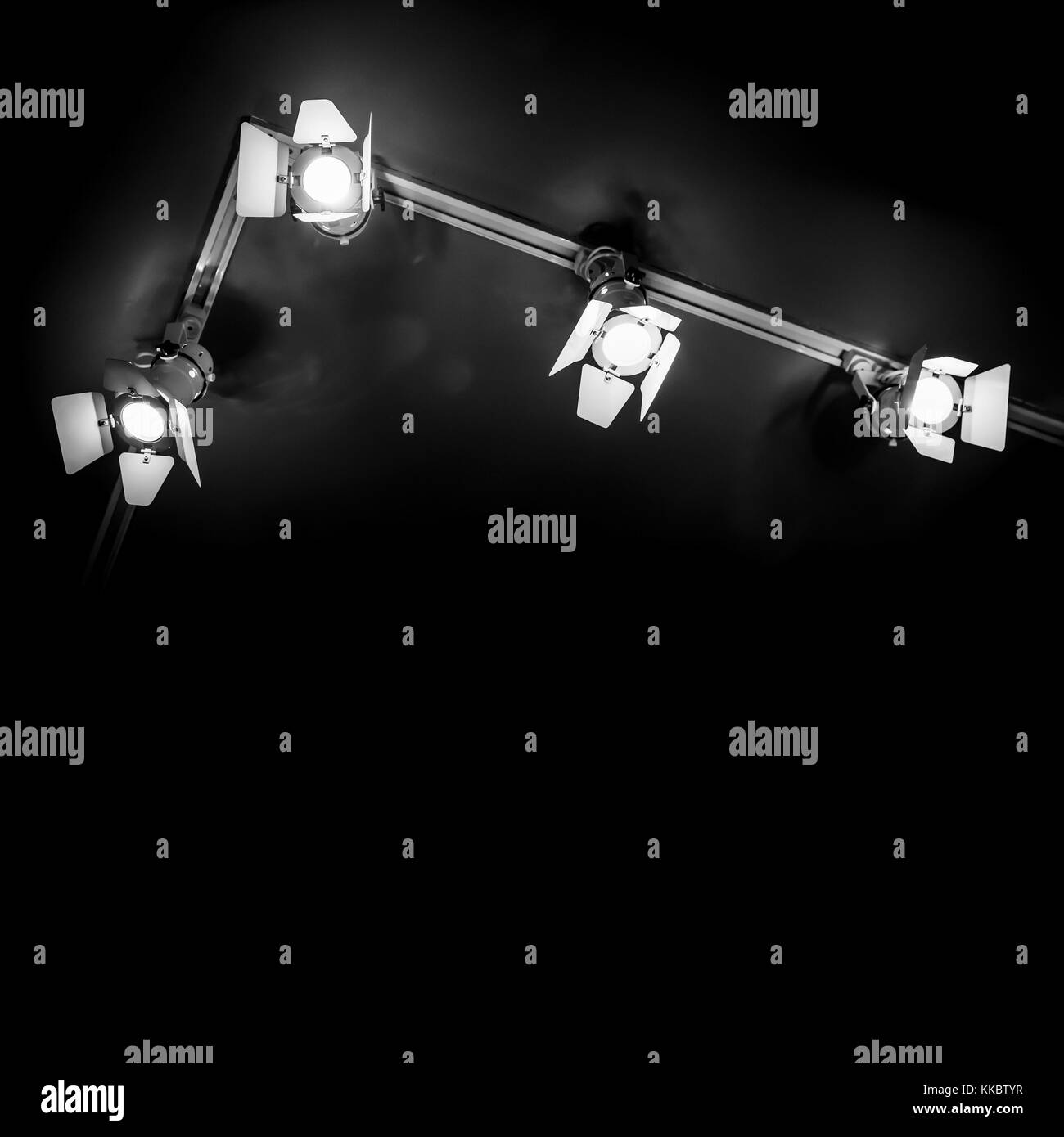 Four spot lights in metal body over black ceiling background, stage ...