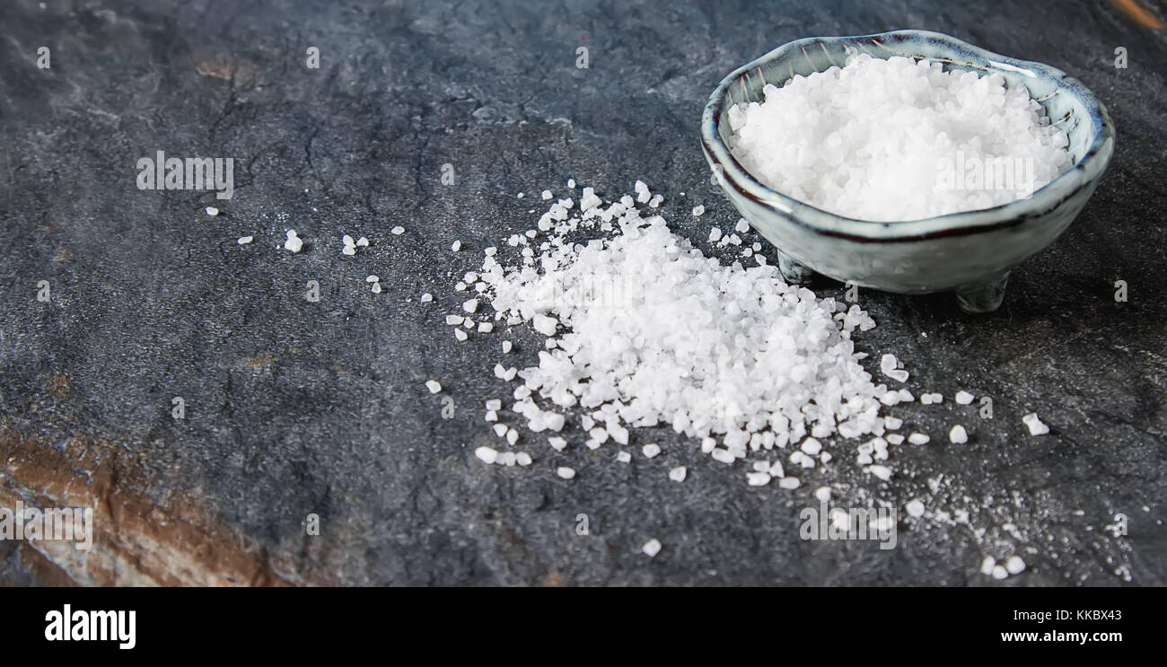 Sea salt on a dark stone background Stock Photo - Alamy