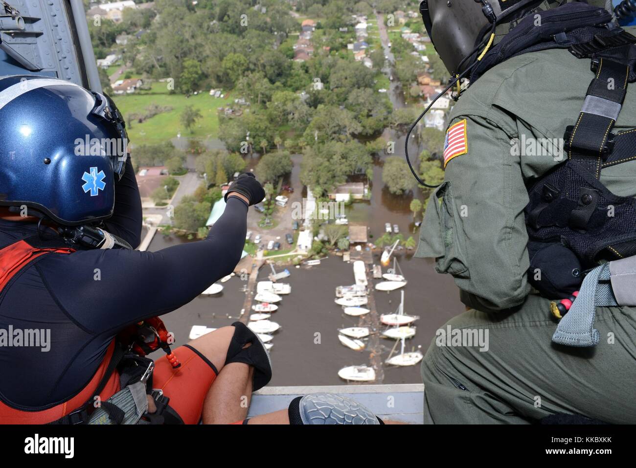U.S. Coast Guard officers try to locate stranded residents in a flooded ...