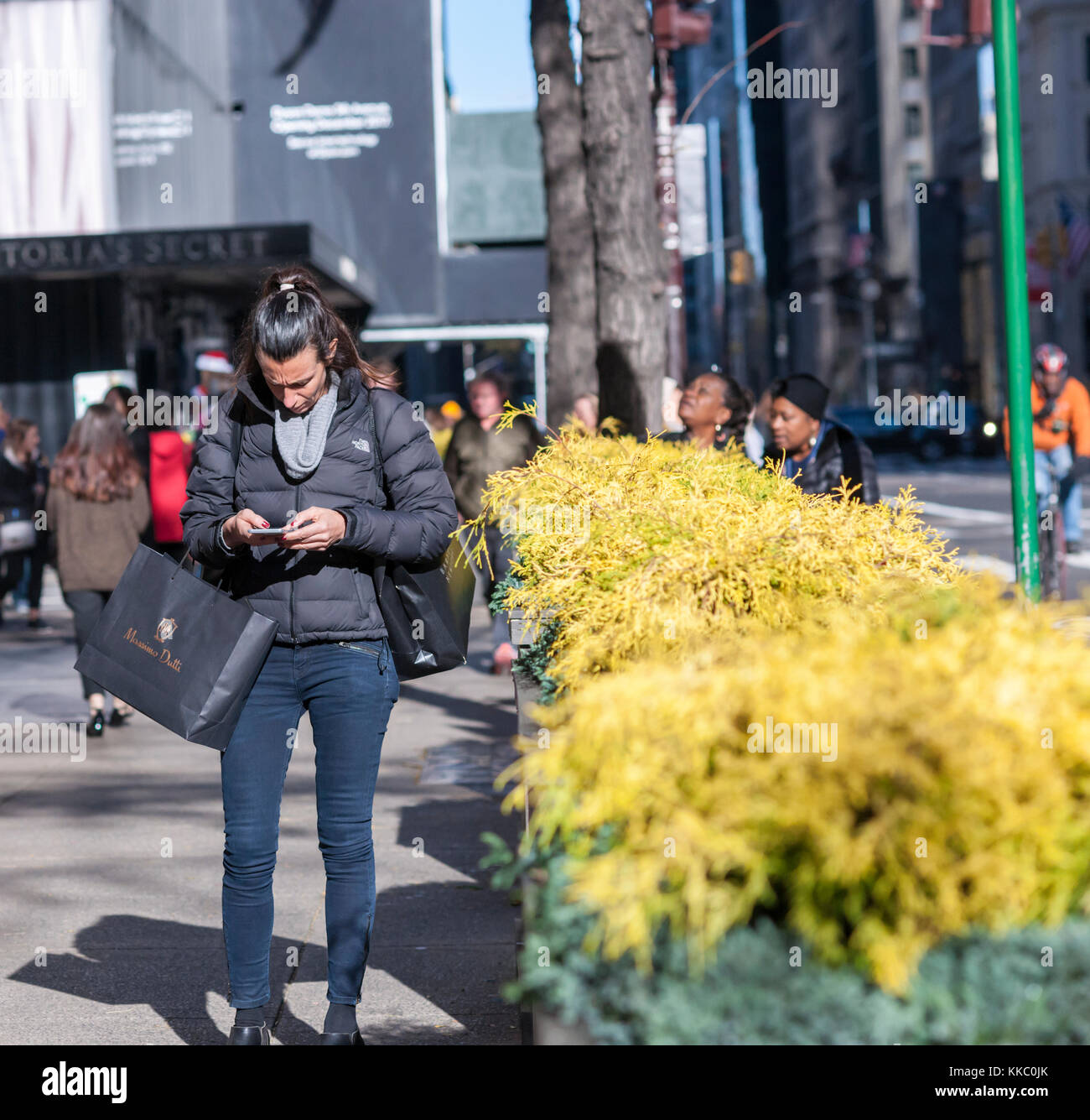 A distracted shopper texts on her smartphone in Midtown in New York on ...