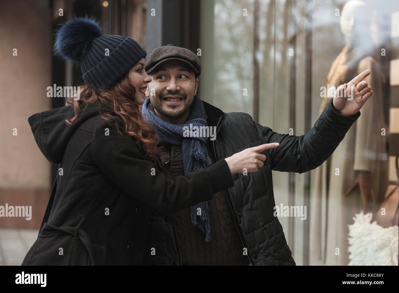 Couple window shopping outdoors in winter city street. Standing in ...